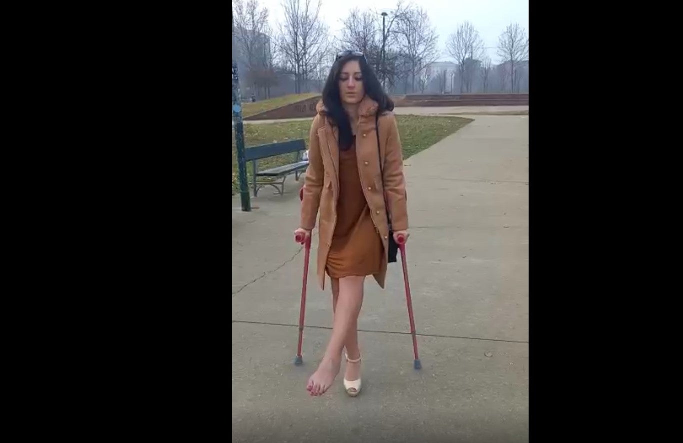 Girl crutching, she has one bare foot with red toenails and on the other foot a heeled shoe - Payhip